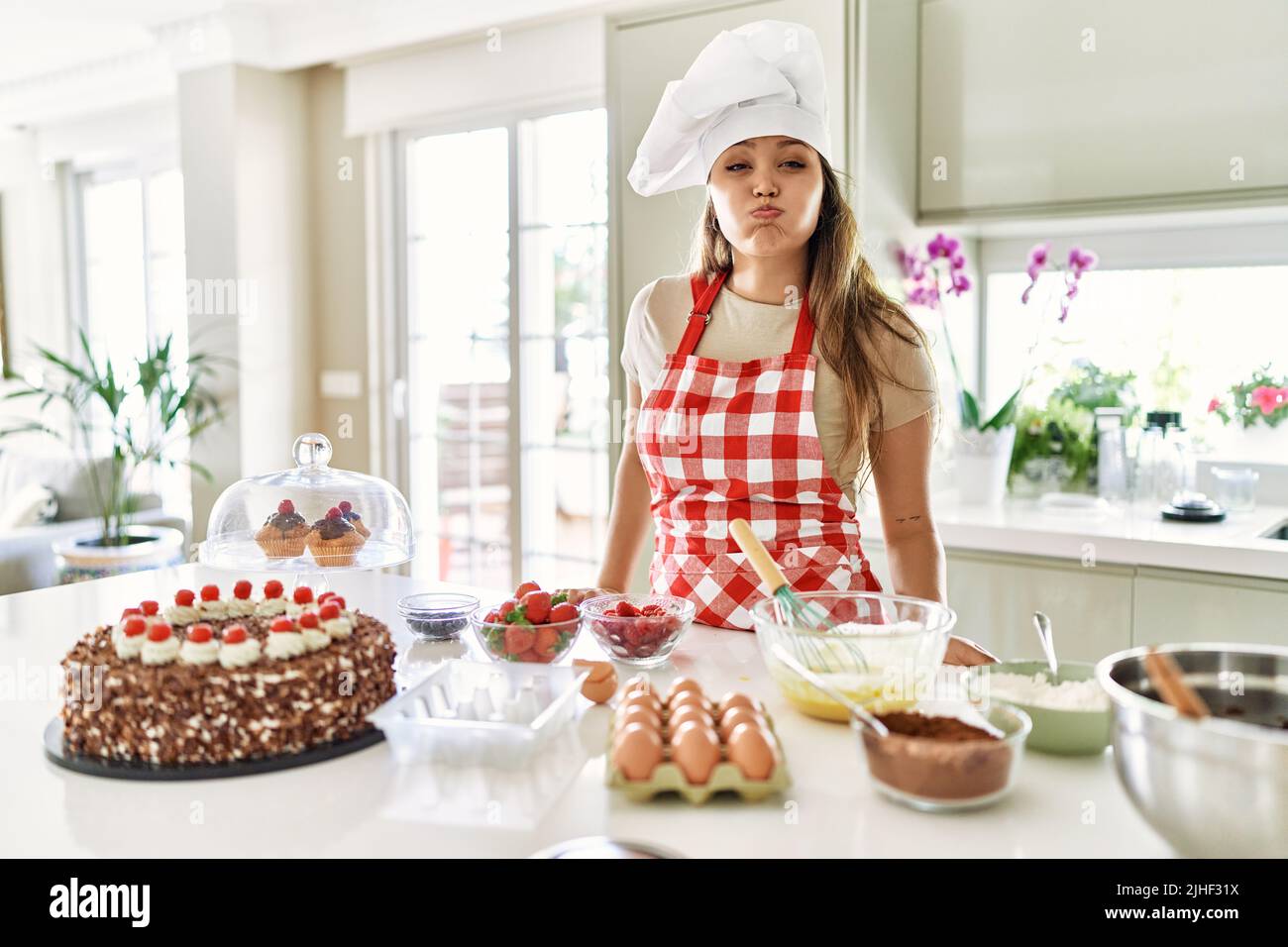 Beautiful young brunette pastry chef woman cooking pastries at the ...