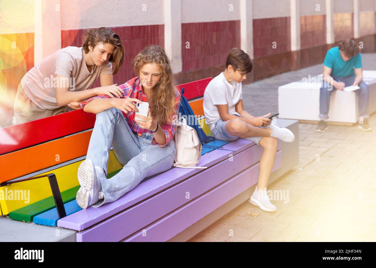 Boy and girl using gadgets during break at school Stock Photo - Alamy