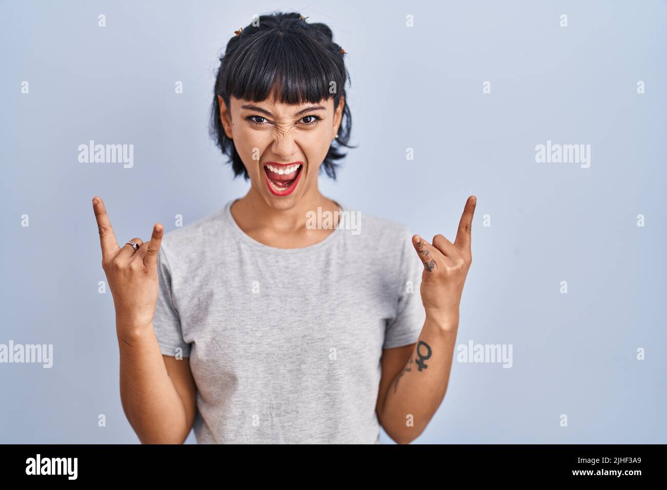 Young hispanic woman wearing casual t shirt over blue background ...