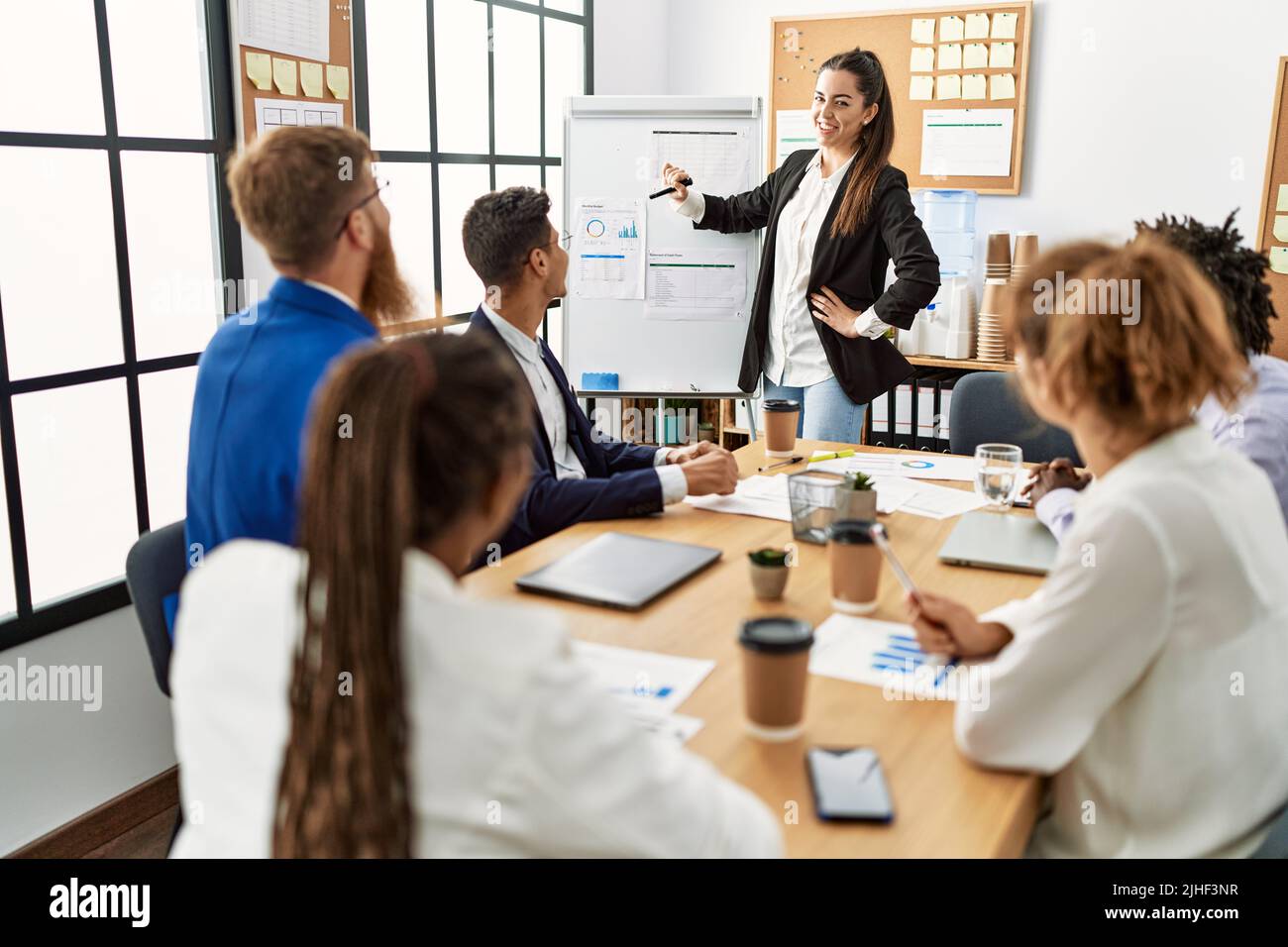 Group of business workers listening hispanic boss woman conference at ...