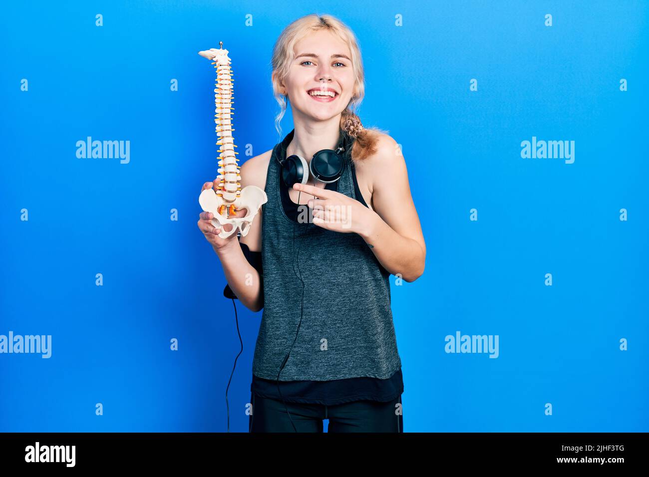 Beautiful caucasian sports woman with blond hair holding anatomical ...