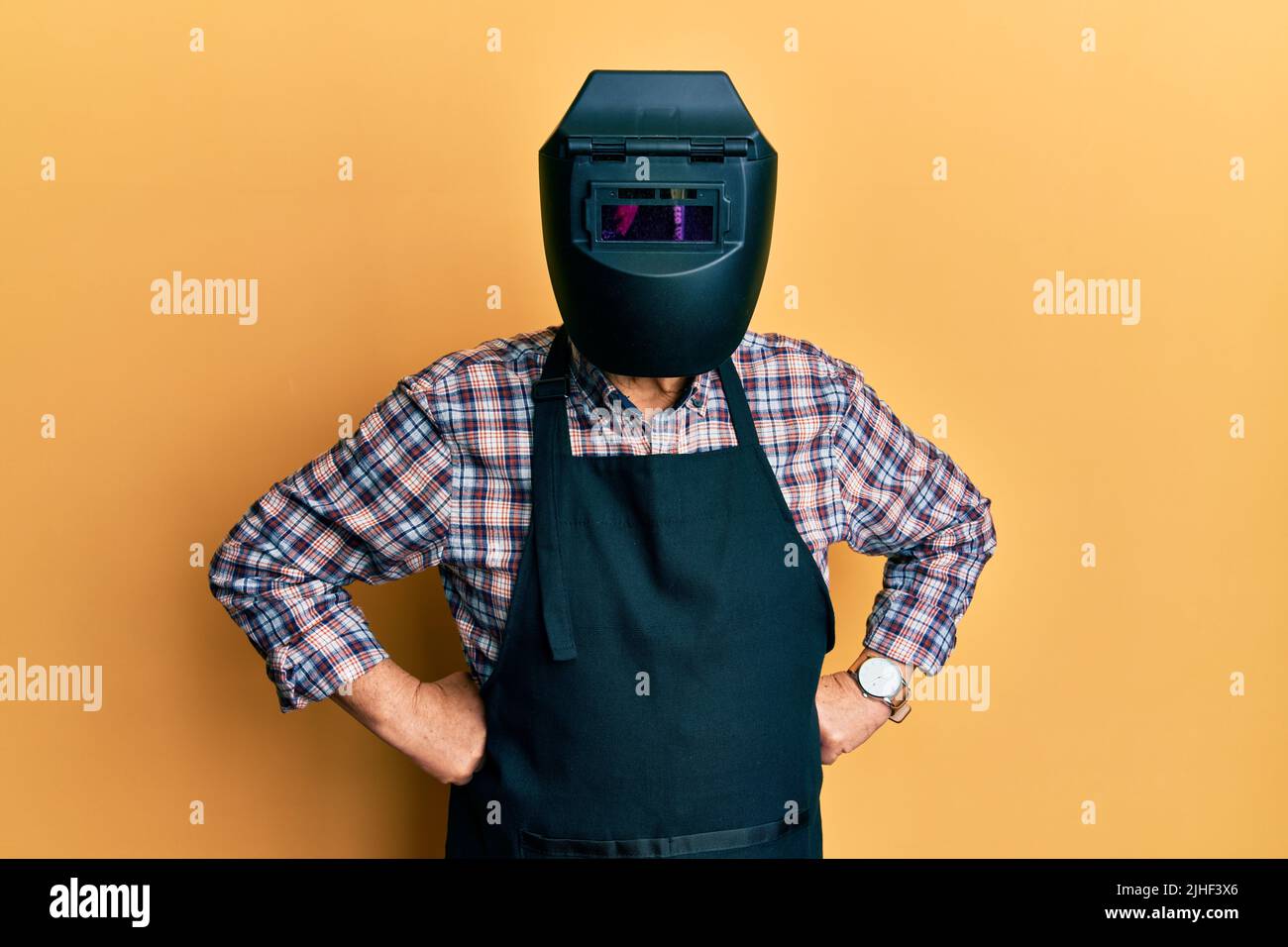 Repair man wearing professional welding mask over head covering face ...