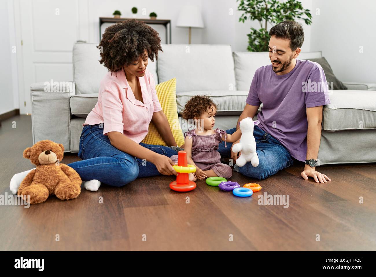 Couple and daughter smiling confident playing with toys sitting on the ...