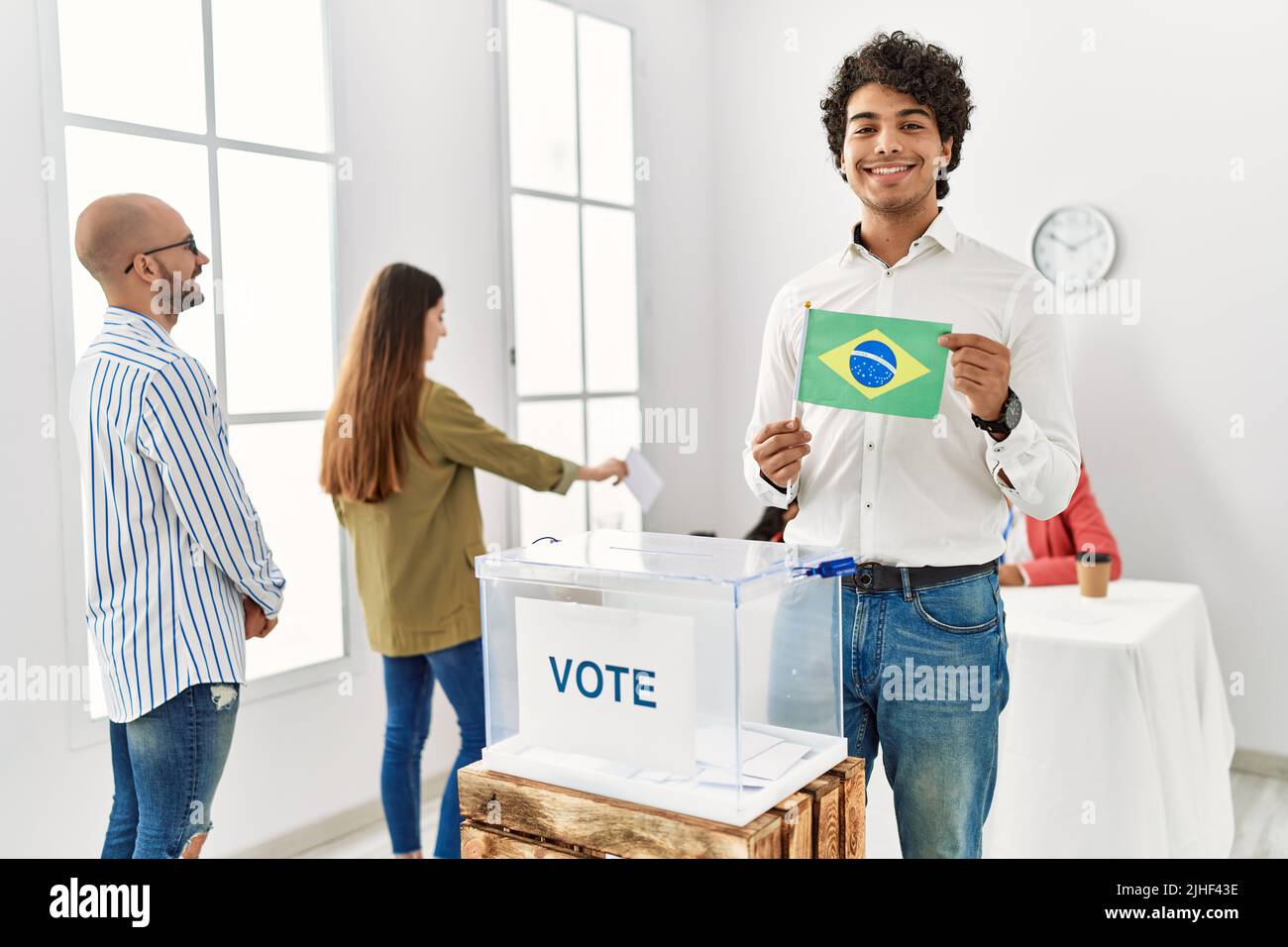 Young brazilian voter man smiling happy holding brazil flag standing by ...