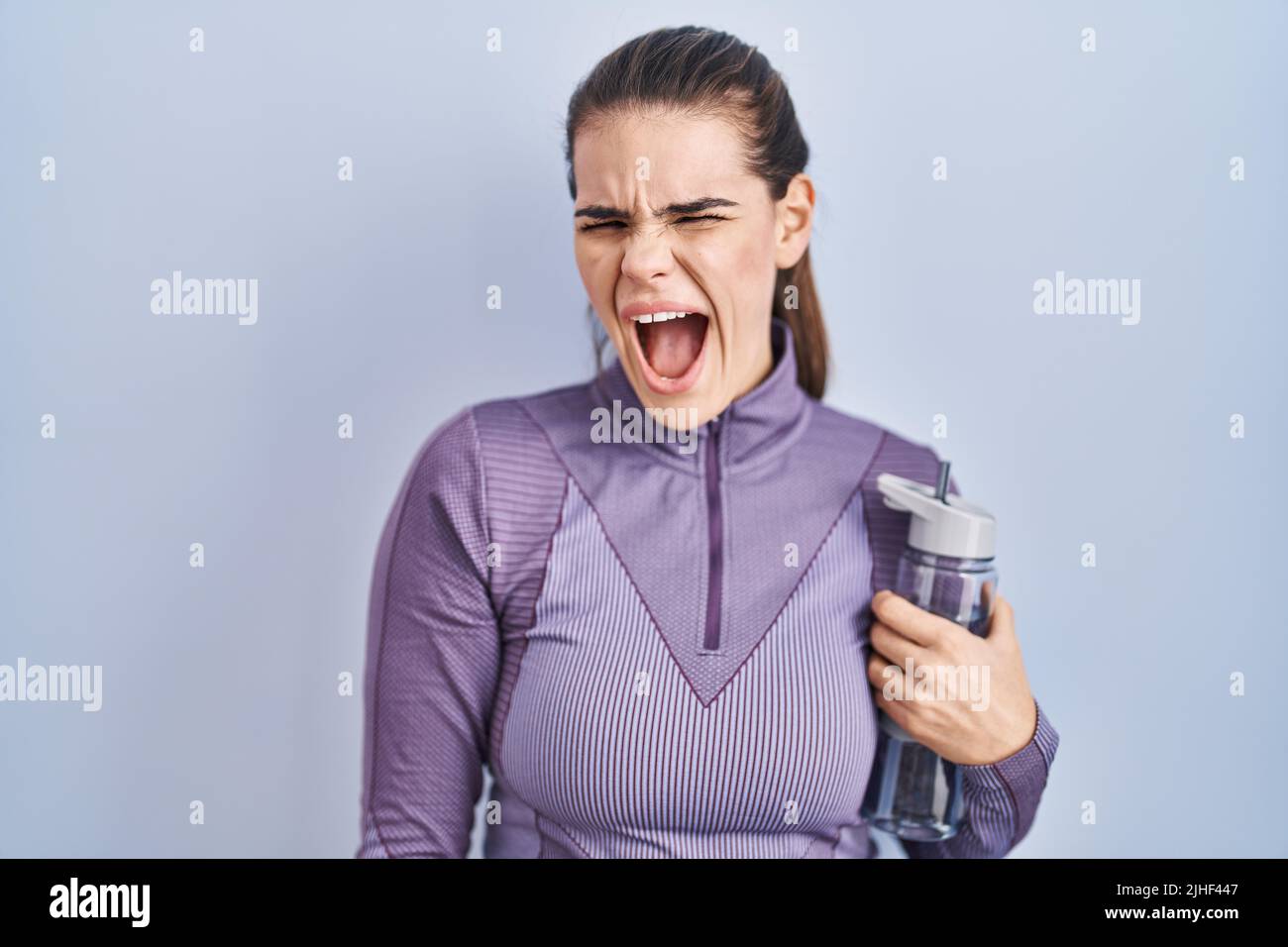 Beautiful Woman Wearing Sportswear Holding Water Bottle Angry And Mad