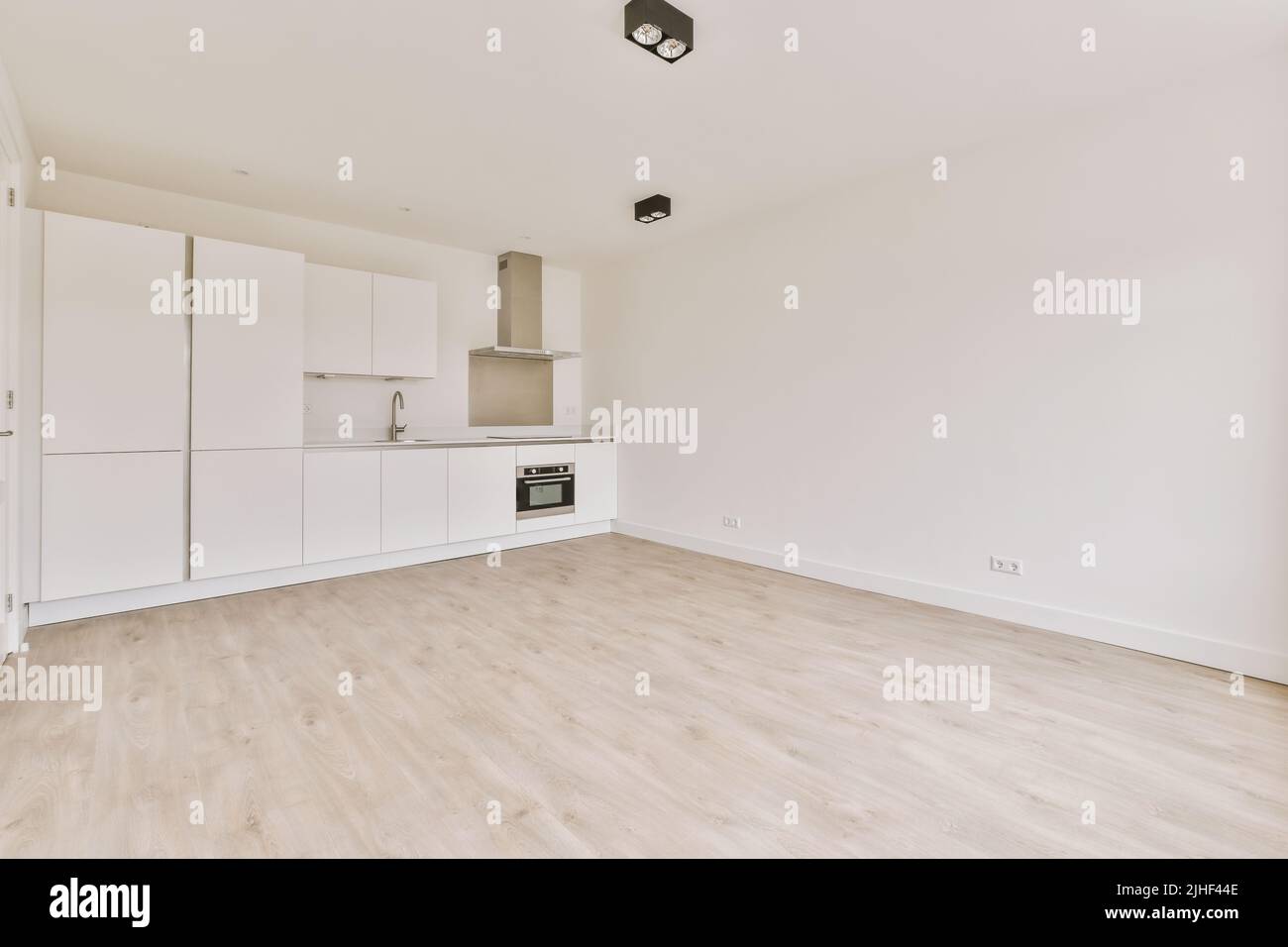 Interior of empty white kitchen with windows and wooden parquet floor ...