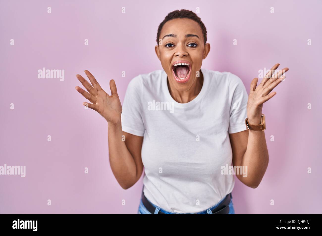 Beautiful african american woman standing over pink background ...