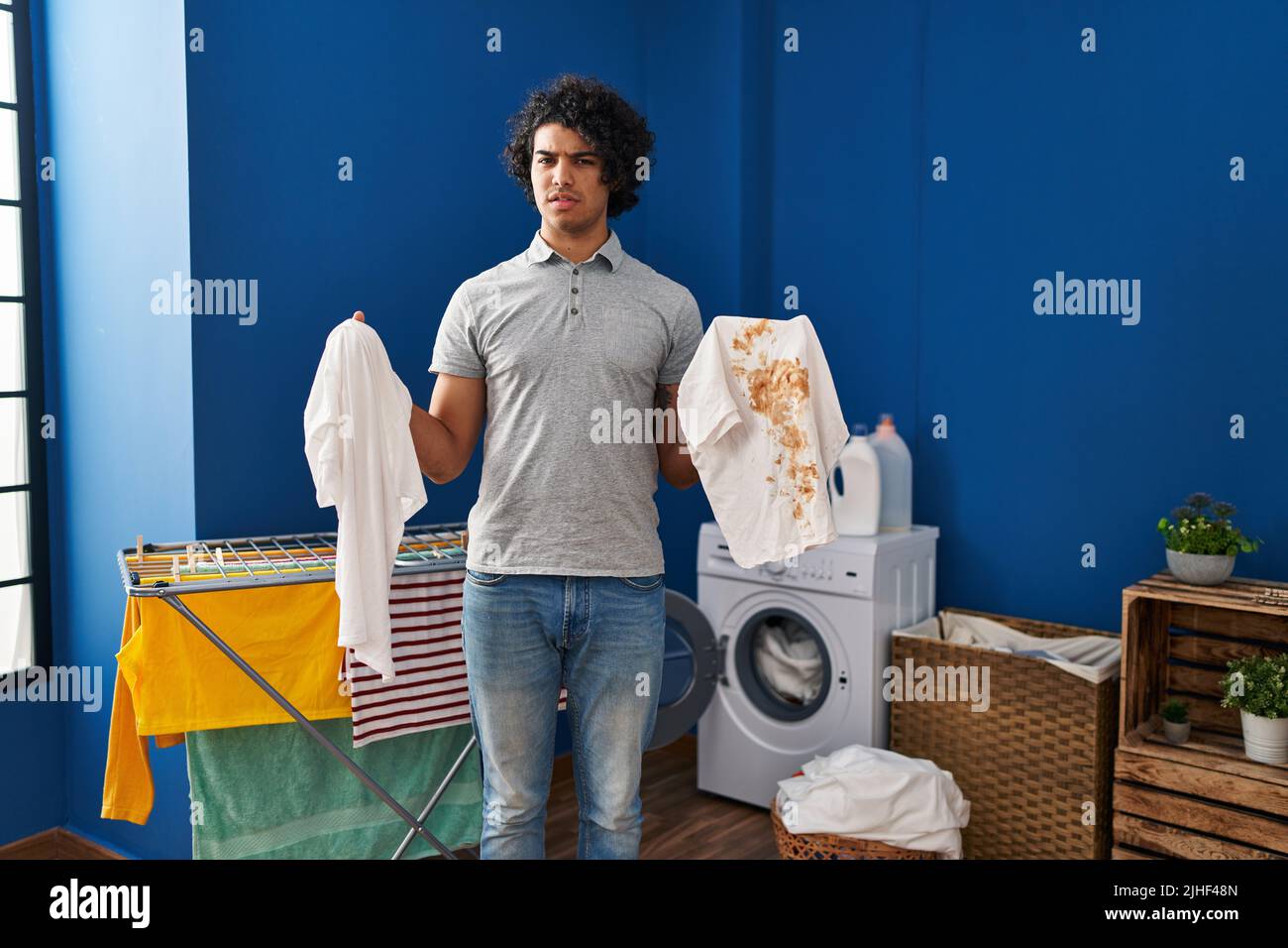 Hispanic man with curly hair holding clean white t shirt and t shirt ...