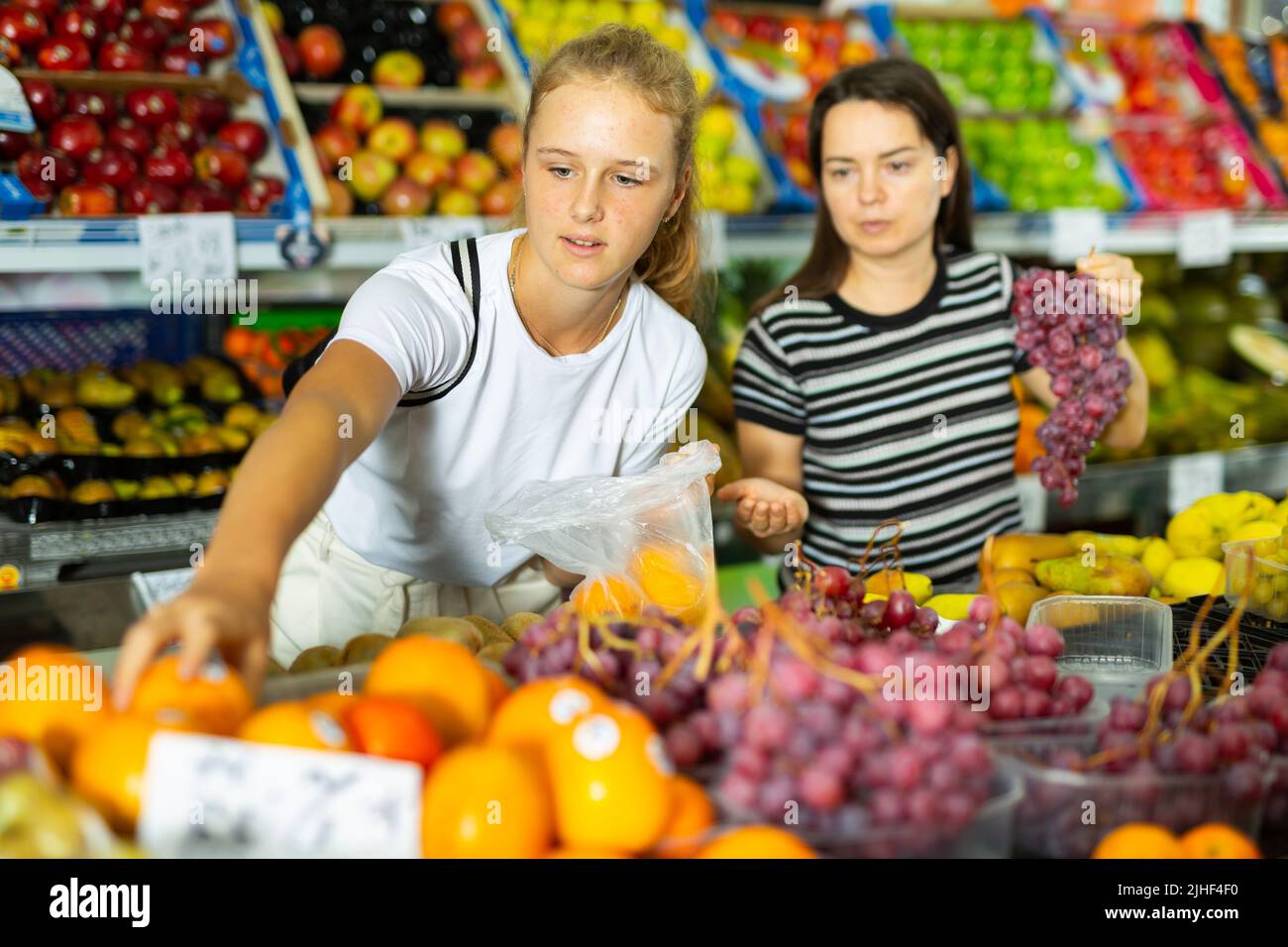 Teenage girl and her mother buying grape at grocery Stock Photo - Alamy