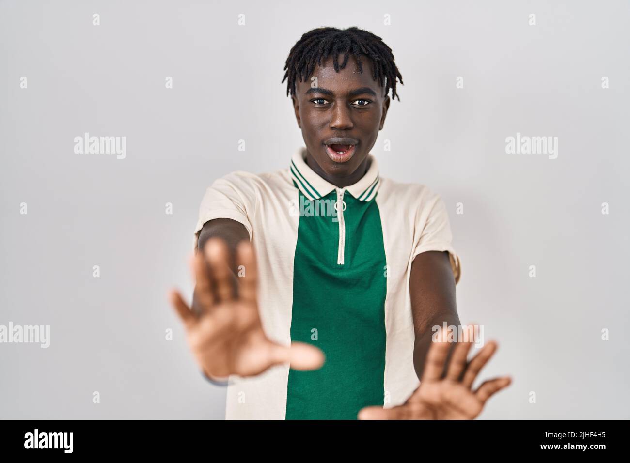 African man with dreadlocks standing over isolated background afraid ...