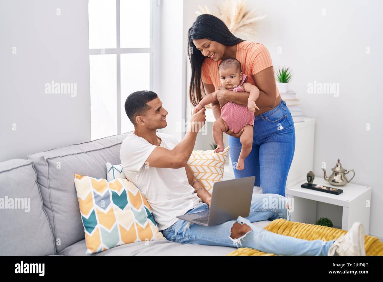 Hispanic family using laptop sitting on sofa at home Stock Photo - Alamy