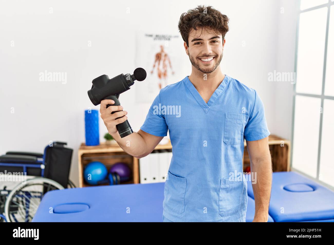 Hispanic physiotherapy man working at pain recovery clinic with muscle ...