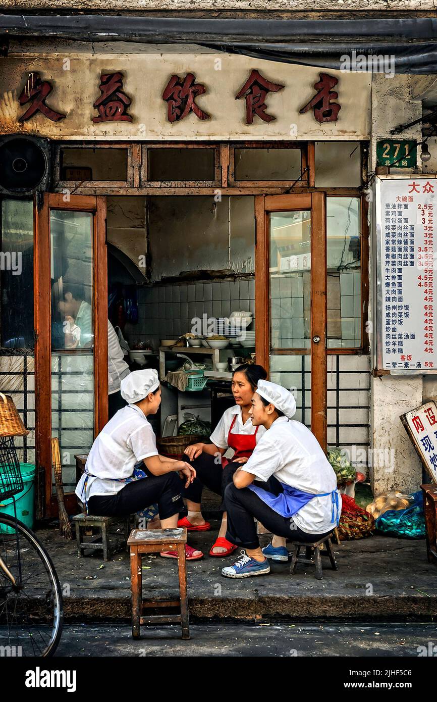 Three sitting female chefs resting at their restaurant in Shanghai ...