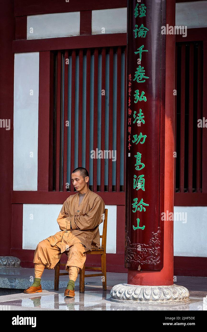 A Buddhist monk sitting on a chair in front of a temple in Xi'an, China ...