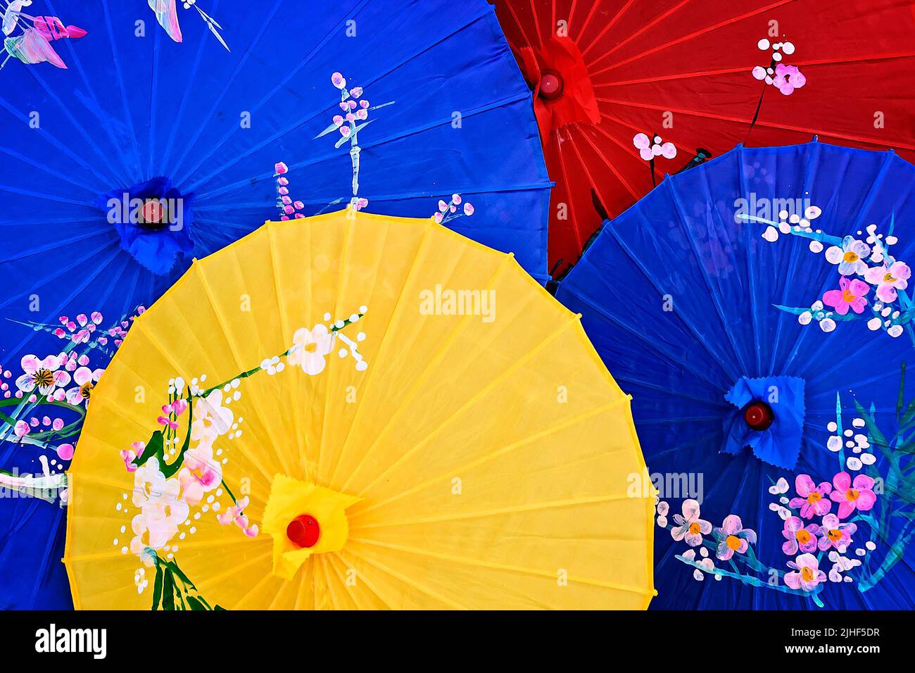 Chinese parasols in the colors blue, red and yellow Stock Photo - Alamy