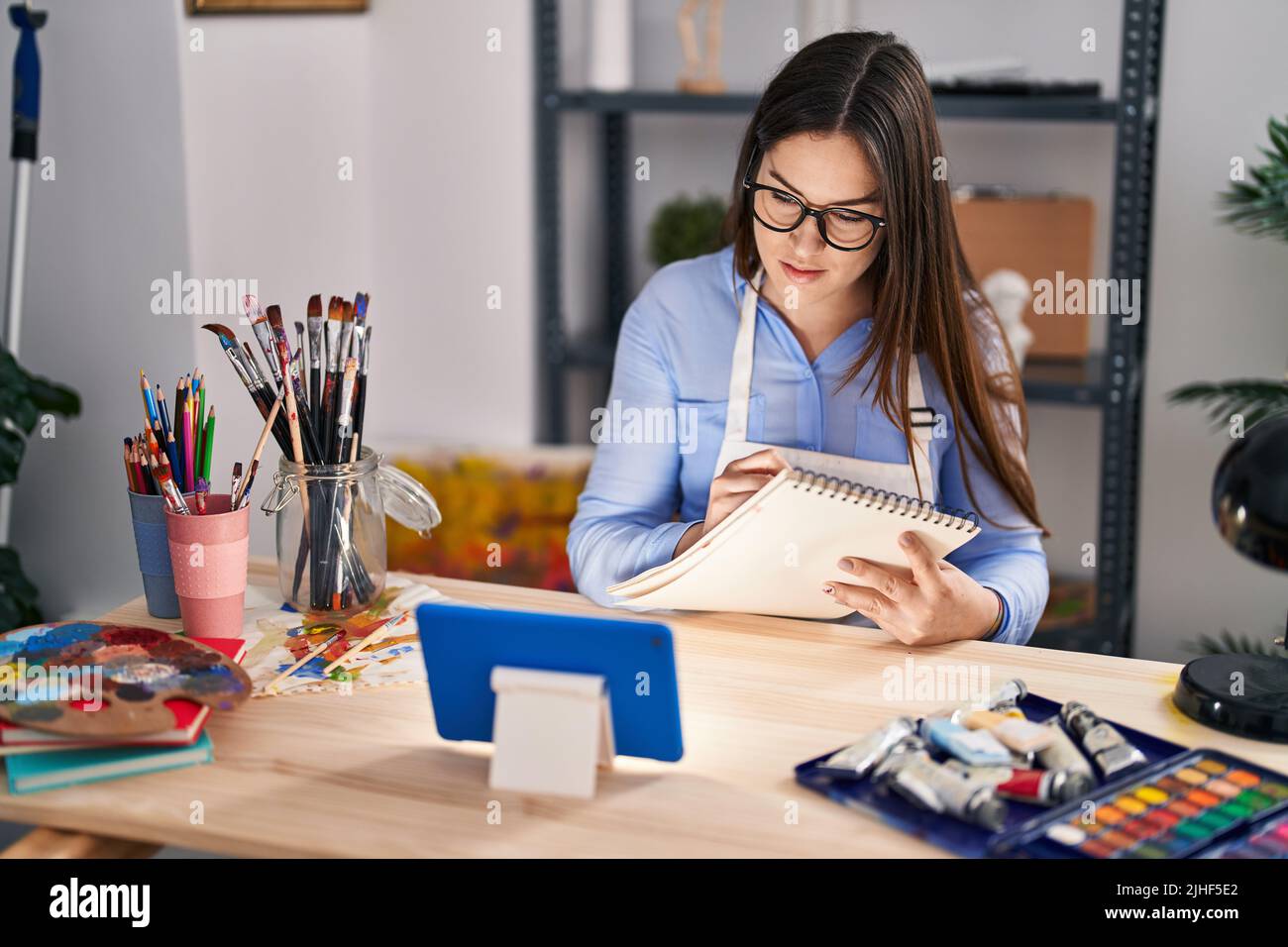 Young woman artist using touchpad drawing on notebook at art studio ...