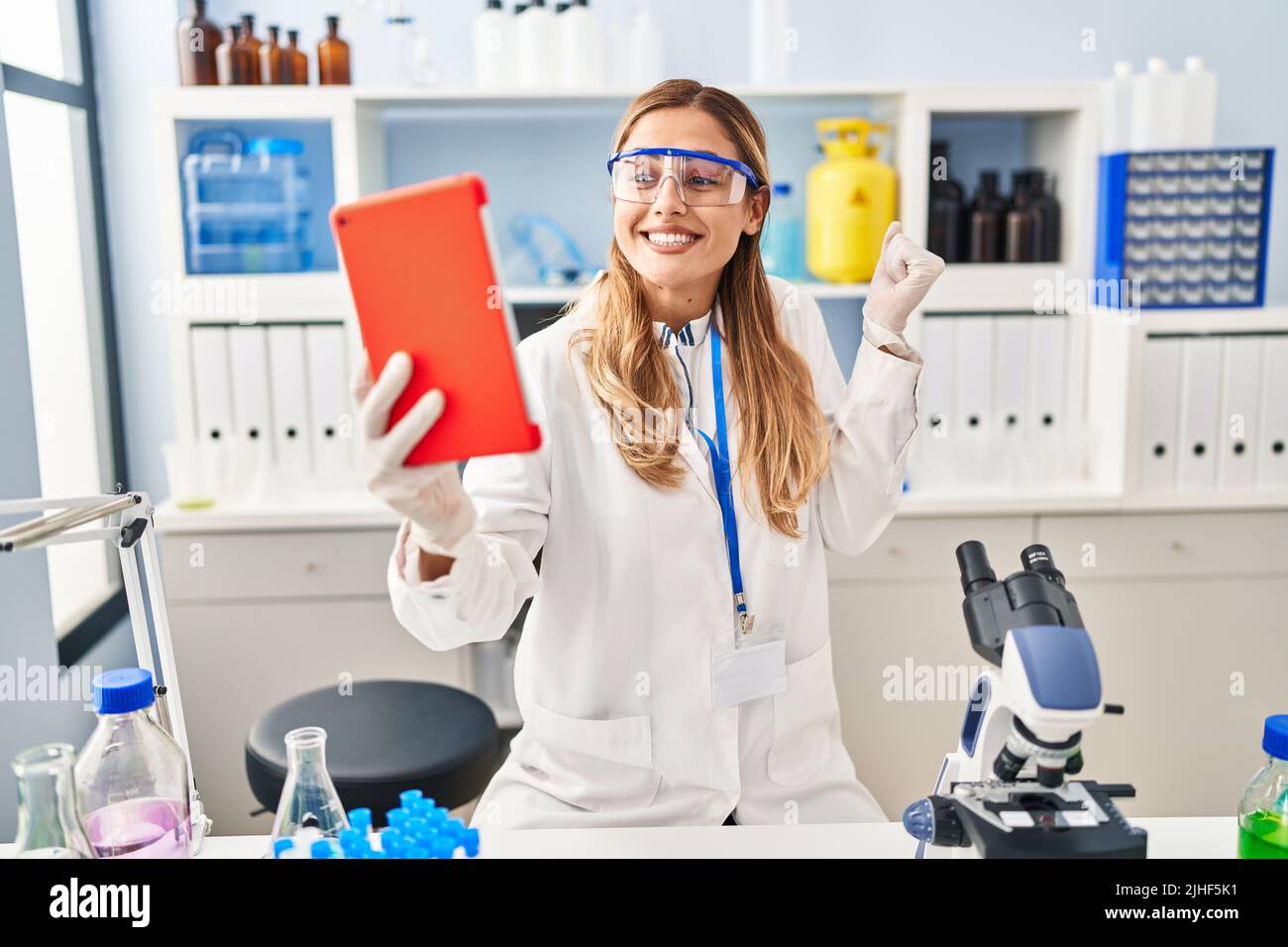 Young blonde scientist woman on video call working at laboratory ...