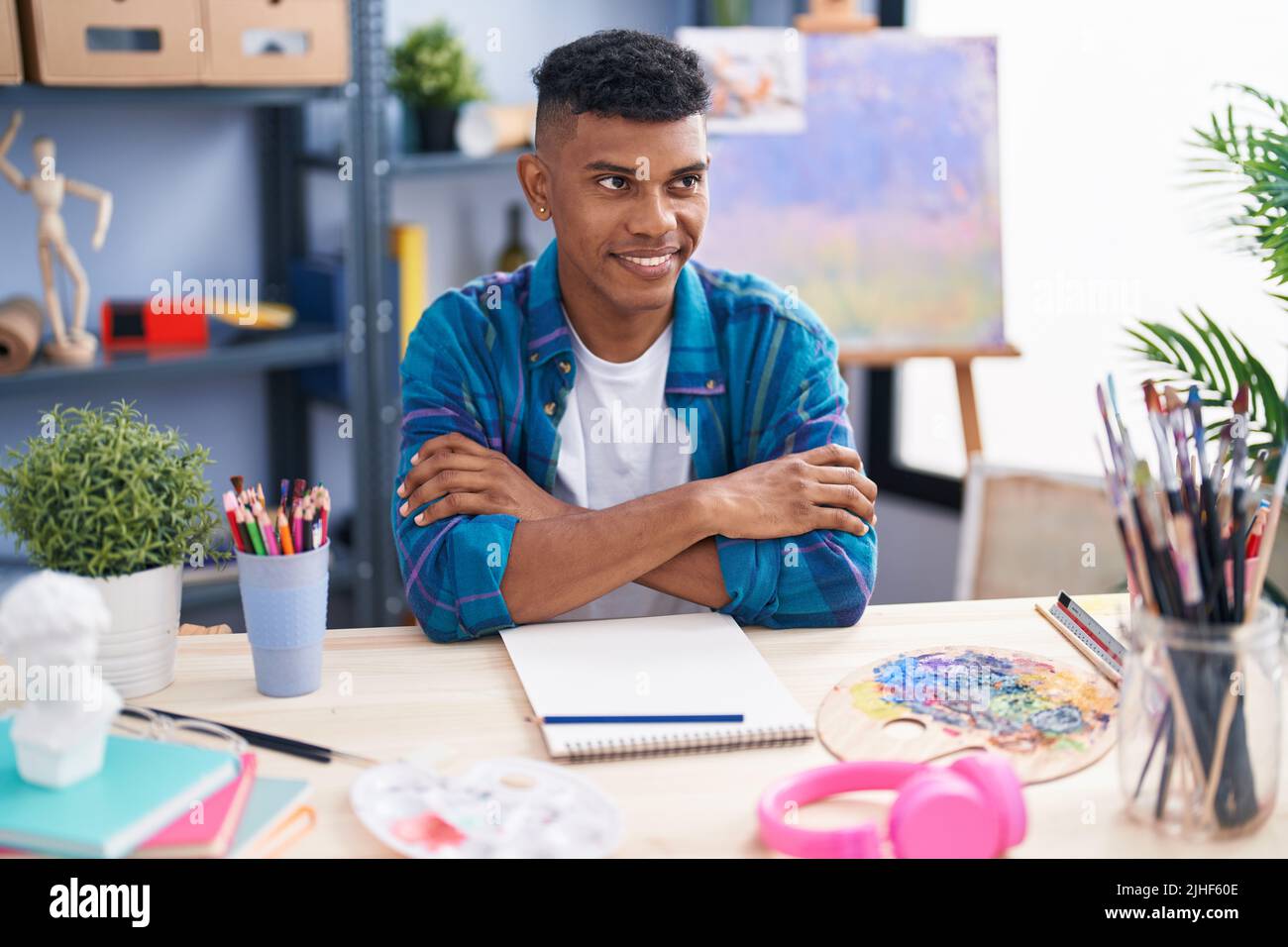 Young latin man artist smiling confident drawing on notebook at art ...