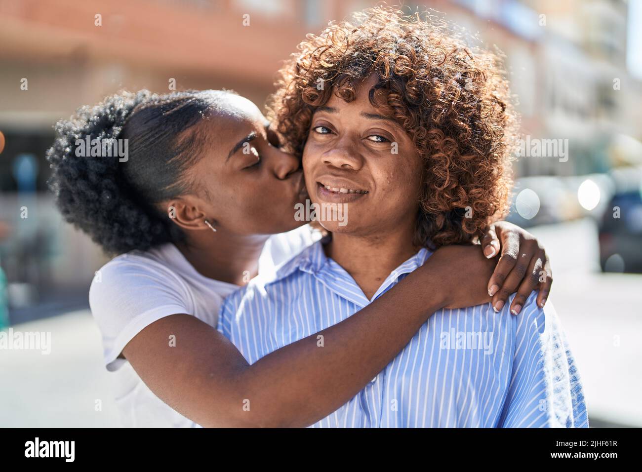 African american women mother and daughter hugging each other kissing at street Stock Photo - Alamy
