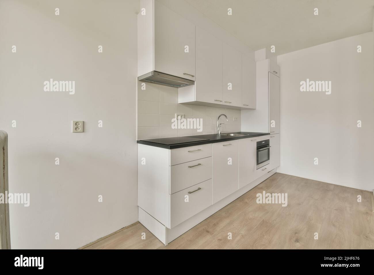 Interior of empty white kitchen with windows and wooden parquet floor ...