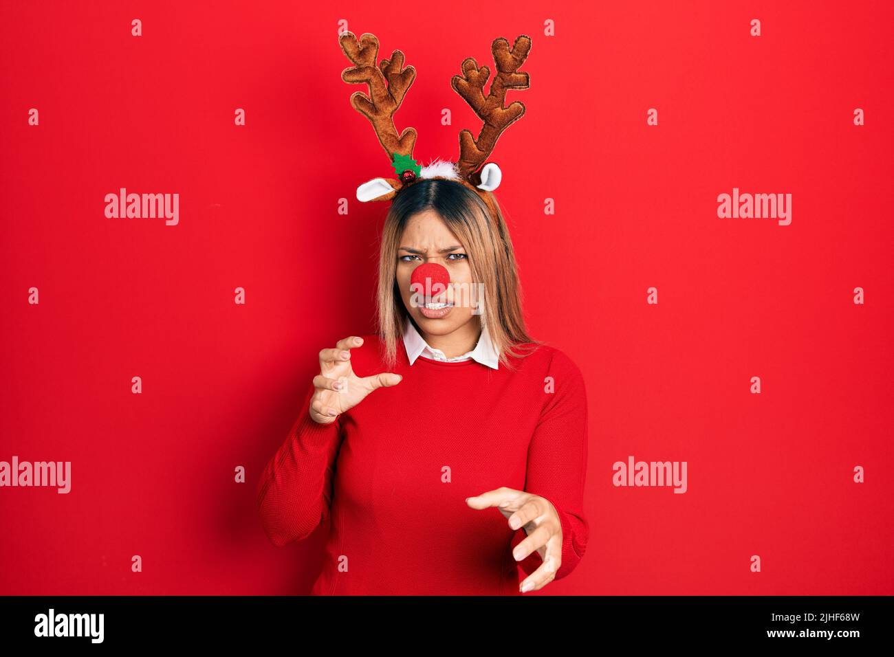 Beautiful hispanic woman wearing deer christmas hat and red nose ...