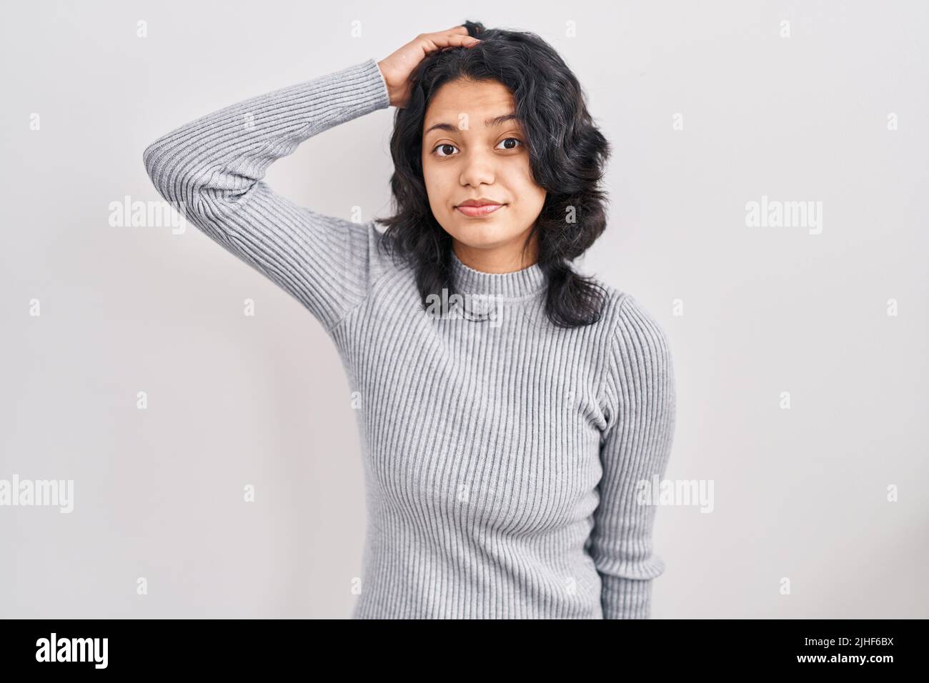 Hispanic woman with dark hair standing over isolated background confuse ...