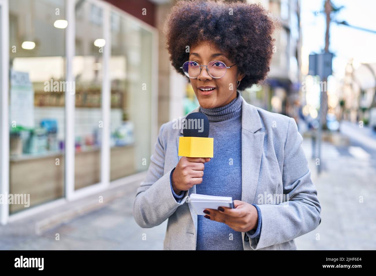 African american woman reporter working using microphone and notebook ...