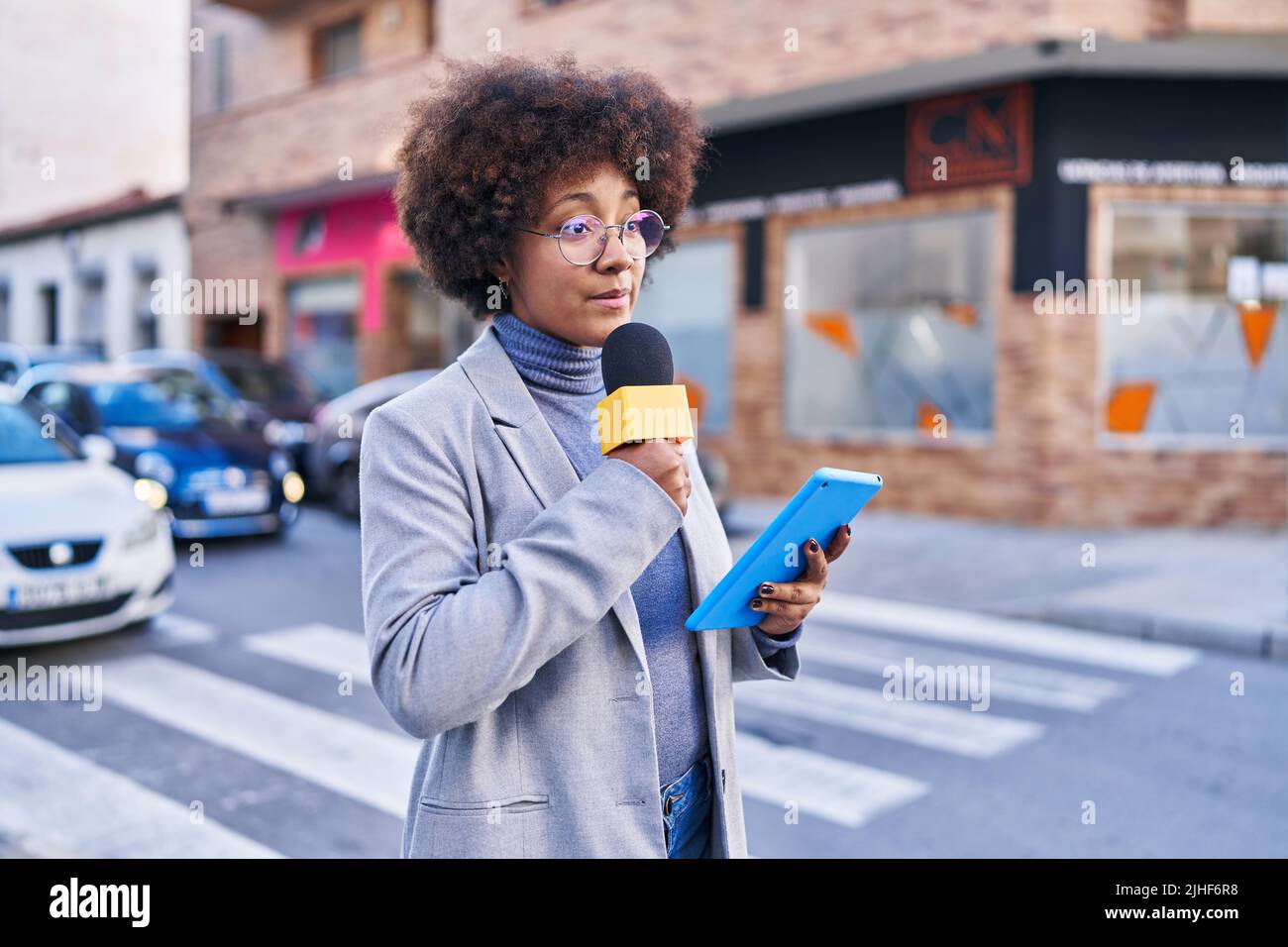 African american woman reporter working using microphone and touchpad ...