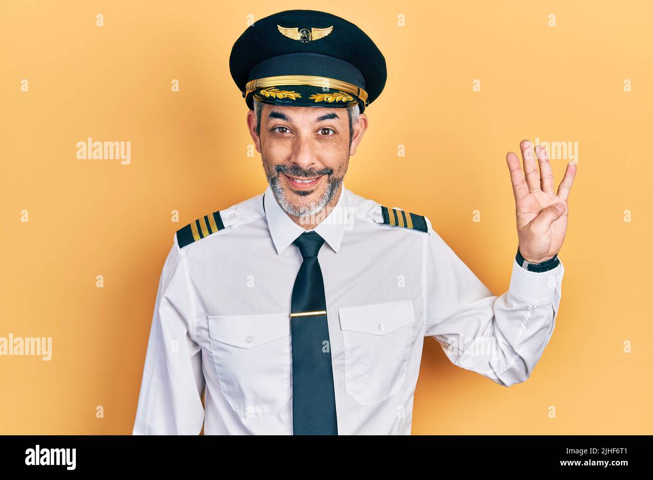 Handsome middle age man with grey hair wearing airplane pilot uniform ...