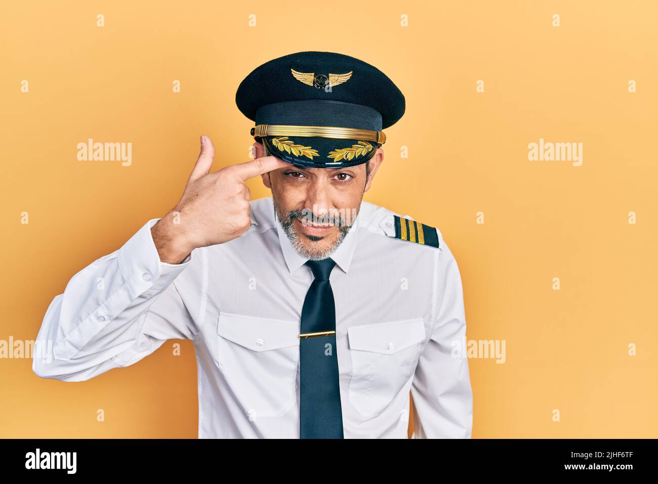 Handsome middle age man with grey hair wearing airplane pilot uniform ...