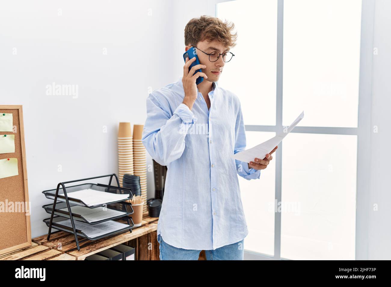 Young caucasian man talking on the smartphone working at office Stock ...