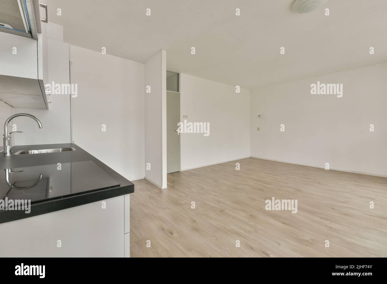 Interior of empty white kitchen with windows and wooden parquet floor ...