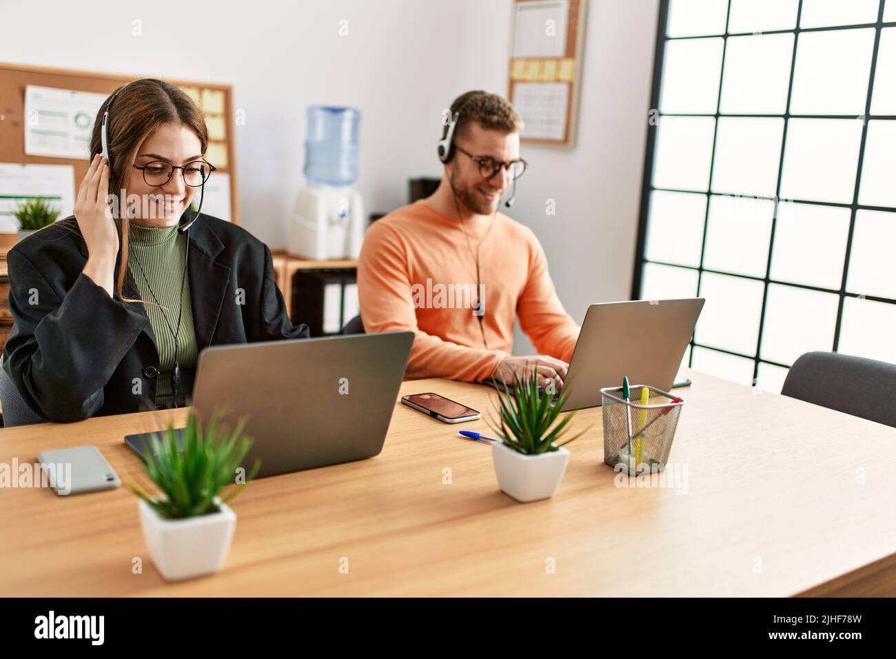 Two caucasian call center agents working at the office Stock Photo - Alamy