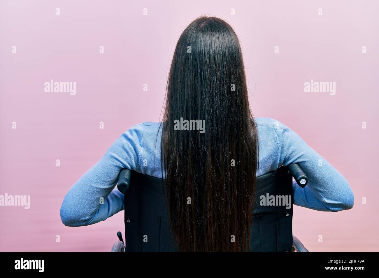 Beautiful woman with blue eyes sitting on wheelchair standing backwards ...