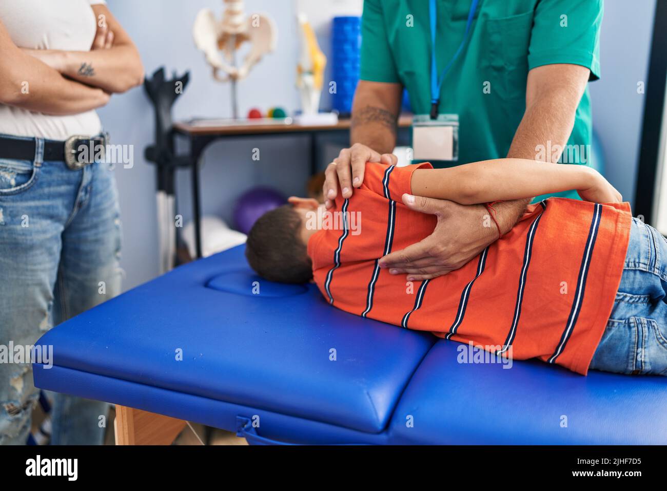 Family having physiotherapy session massaging child back at rehab ...