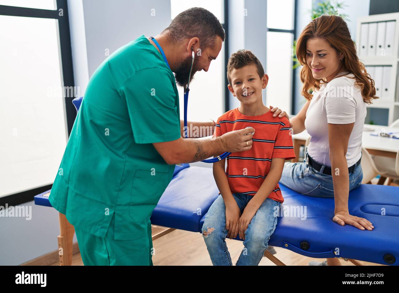 Family having medical consultation auscultating heart at clinic Stock ...
