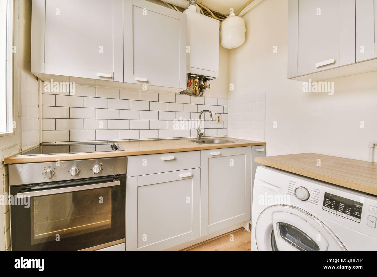 Fragment of interior of light narrow home kitchen with minimalist style ...