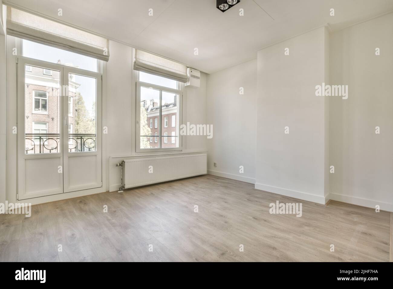 Plastic window and radiator on white wall in empty light room at home ...