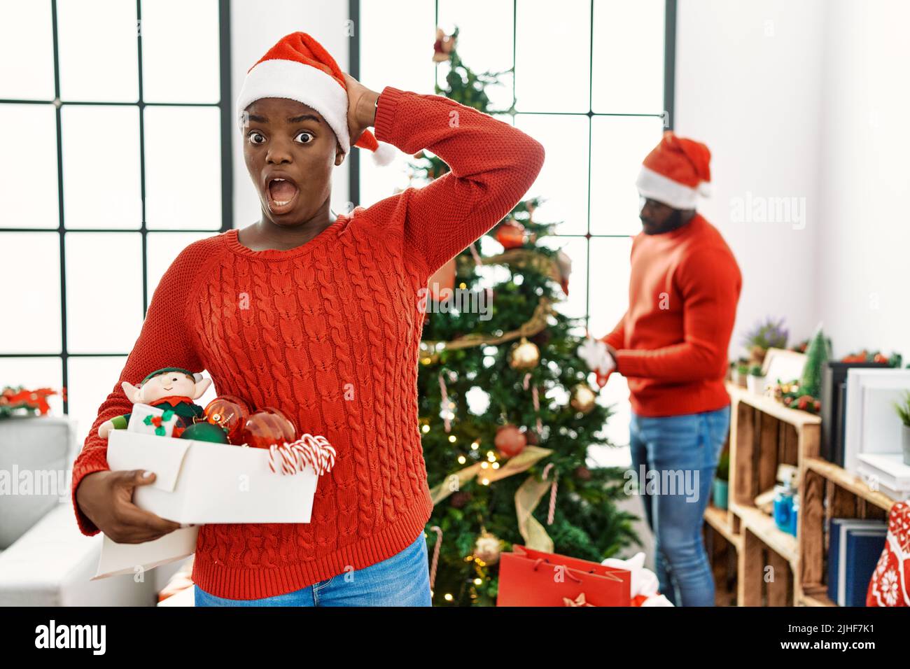 Young african american couple standing by christmas tree crazy and ...