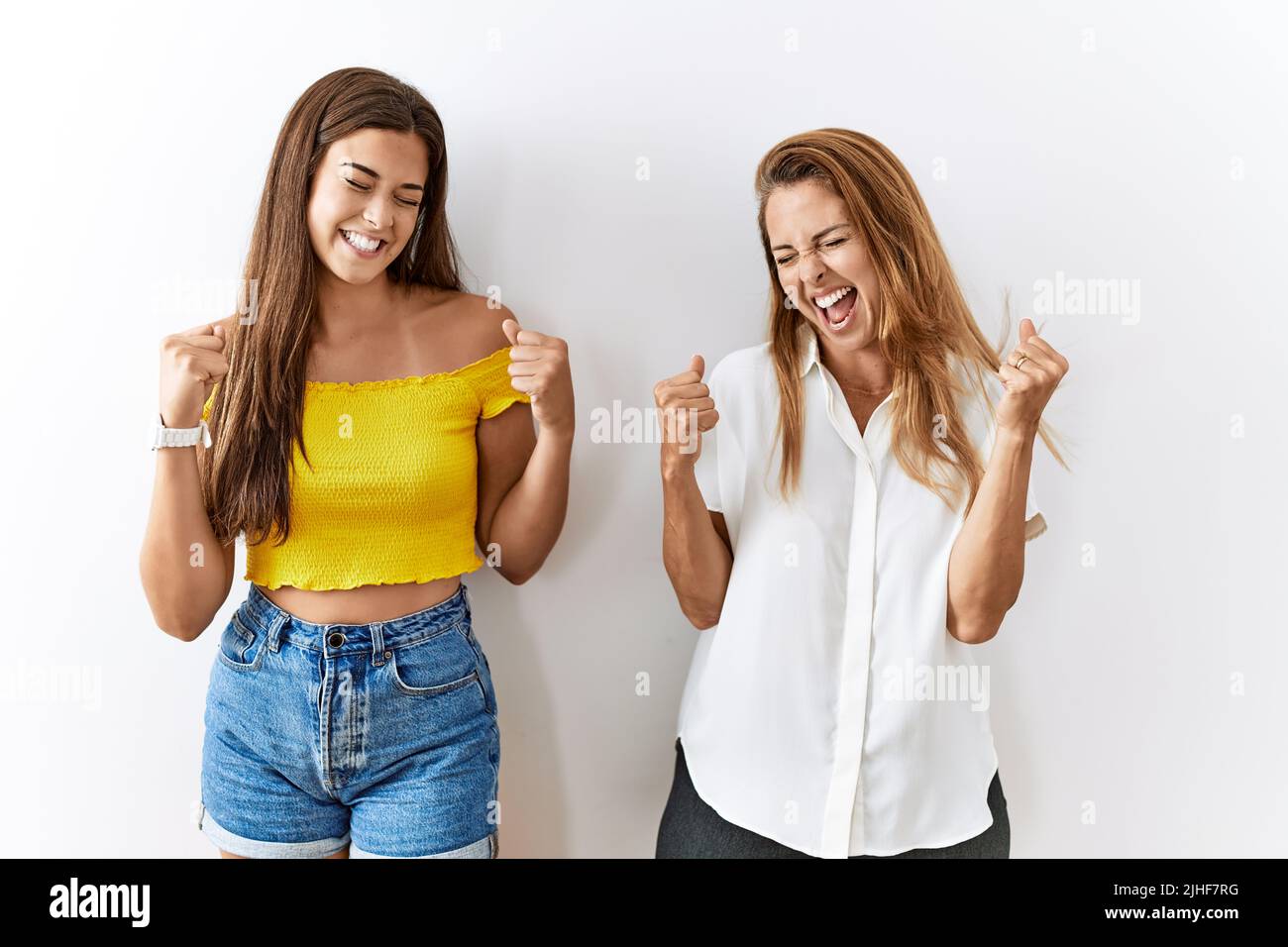 Mother and daughter together standing together over isolated background ...