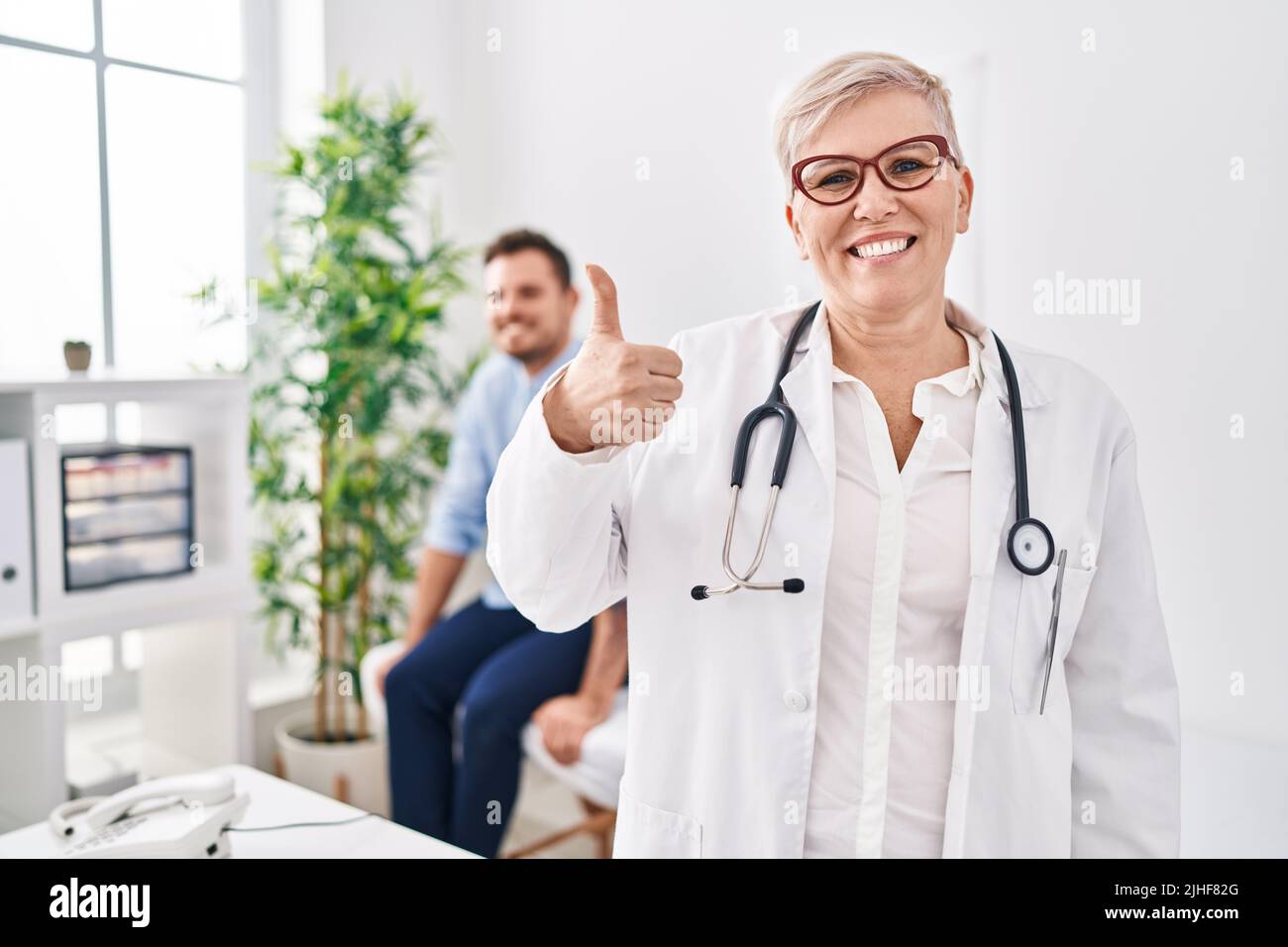 Female doctor wearing uniform and stethoscope at medical clinic smiling ...
