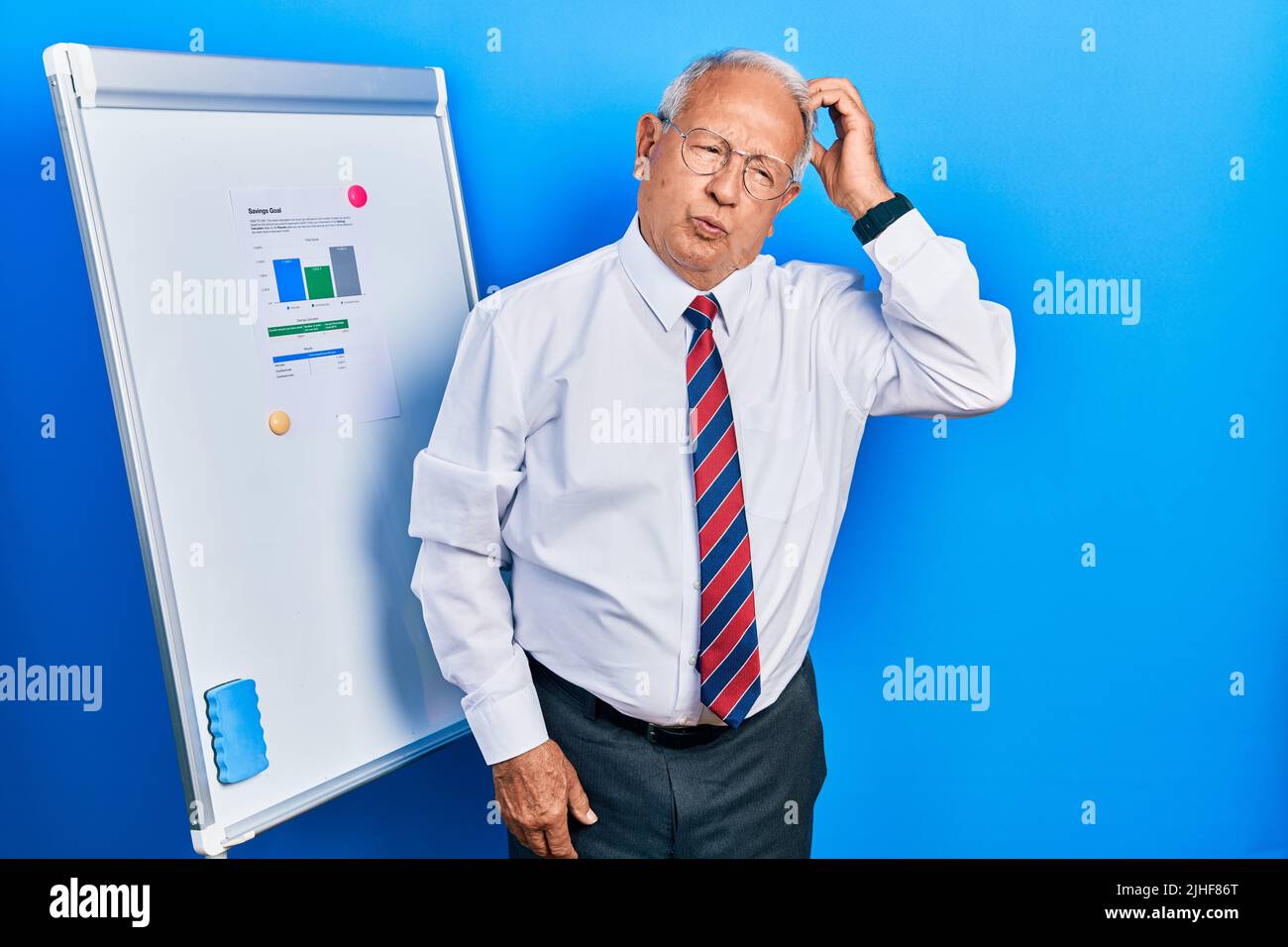 Senior man with grey hair standing by business blackboard confuse and ...