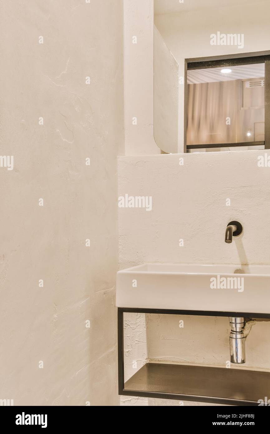 Sink with tap installed on tabletop near mirror and door in ...