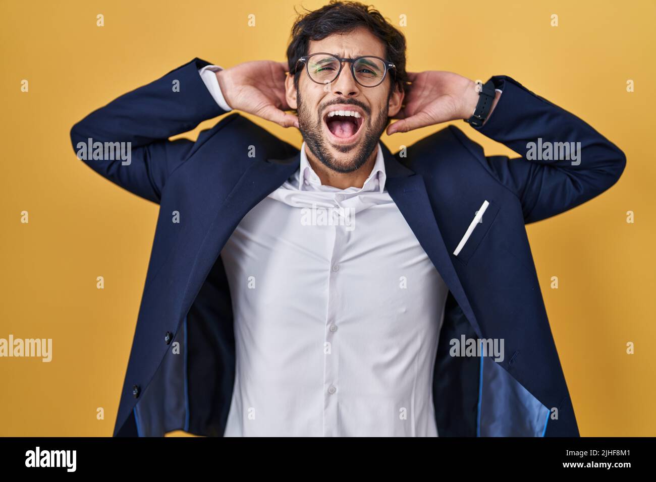Handsome latin man standing over yellow background crazy and scared ...