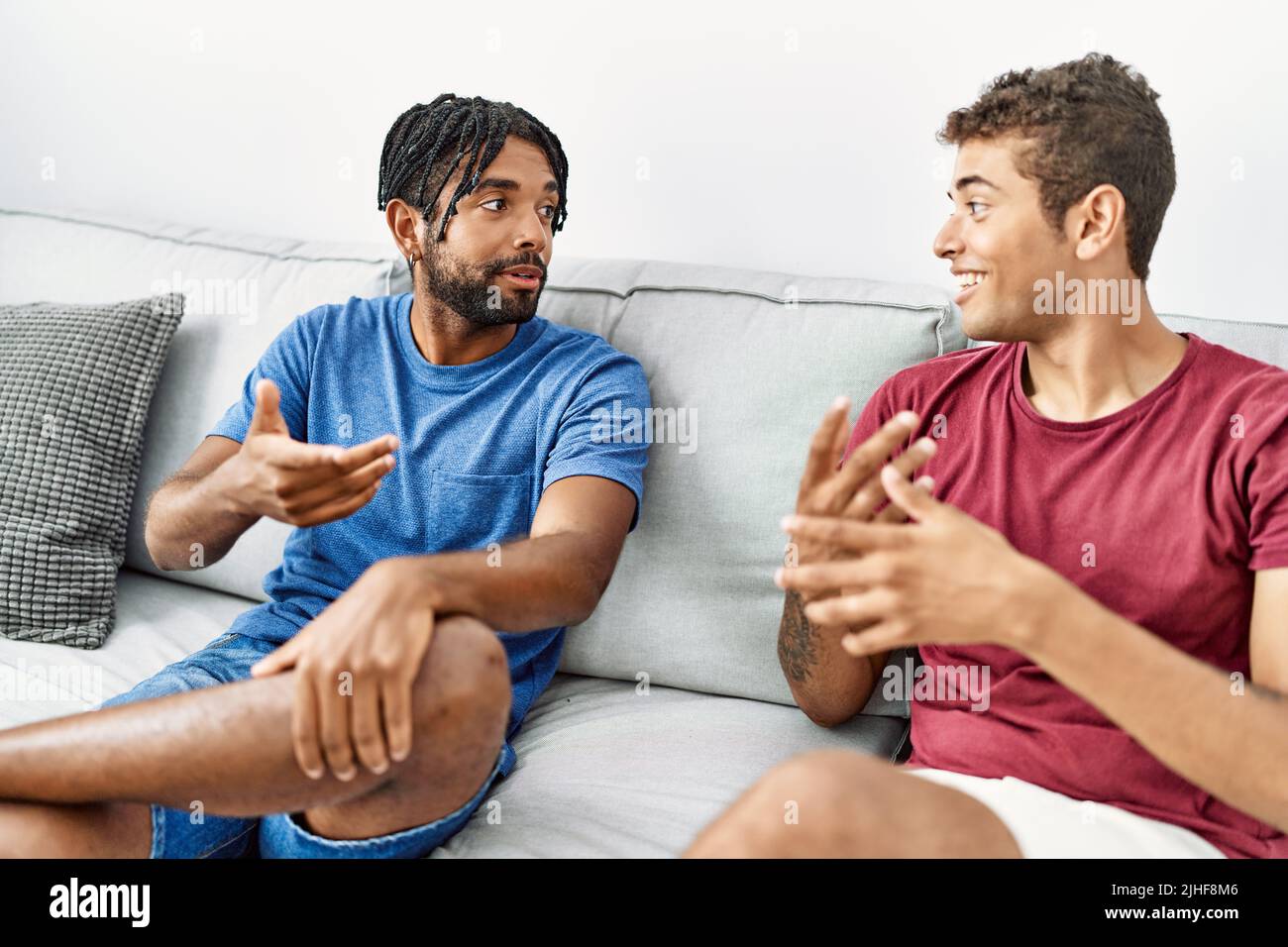 Two men friends having conversation sitting on sofa at home Stock Photo ...