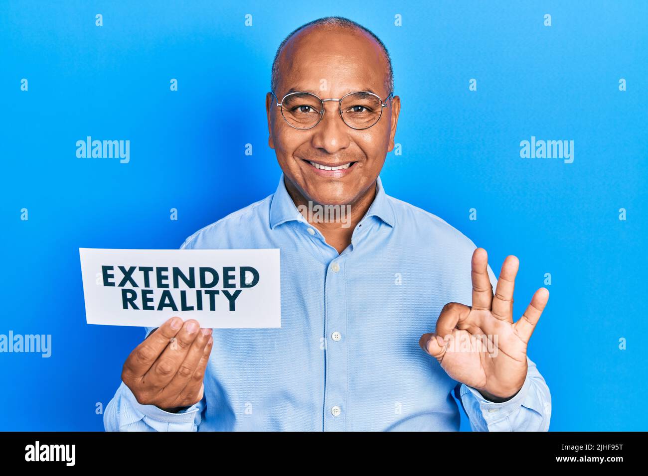 Middle age latin man holding paper with extended reality message doing ...
