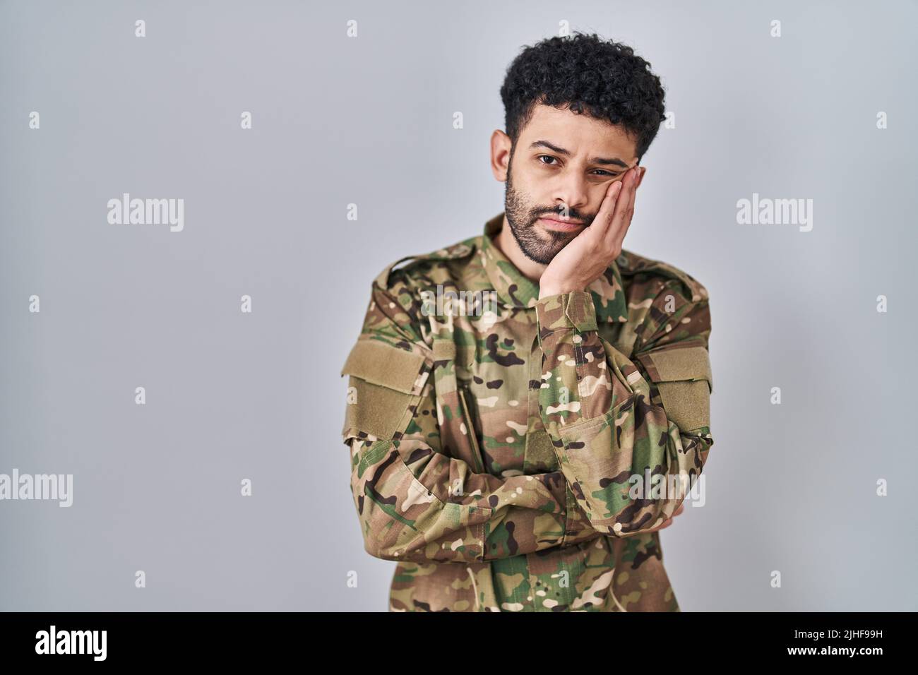 Arab man wearing camouflage army uniform thinking looking tired and ...