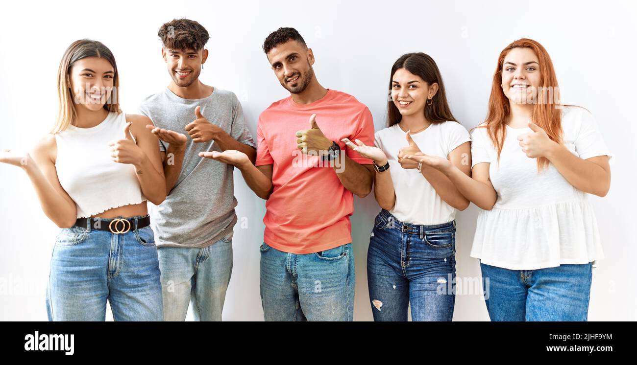 Group of young friends standing together over isolated background ...