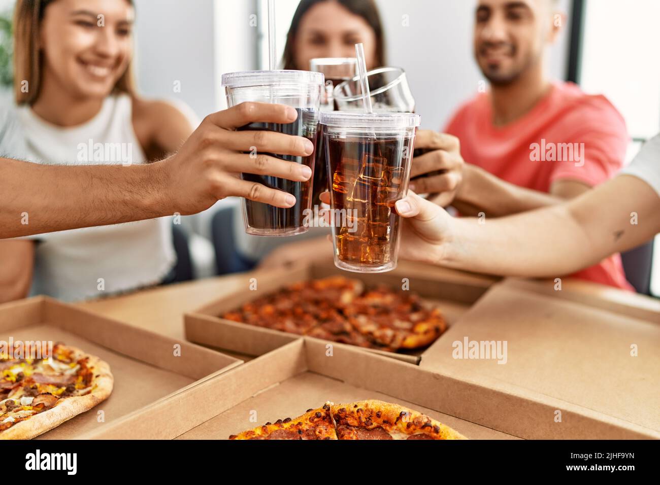 Group of young friends smiling happy eating italian pizza and toasting ...