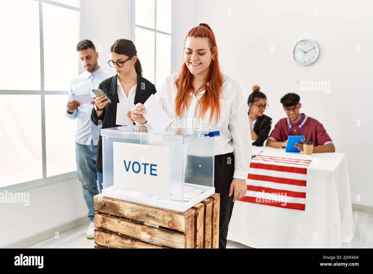 Young american voter woman smiling happy putting ballot in voting box ...